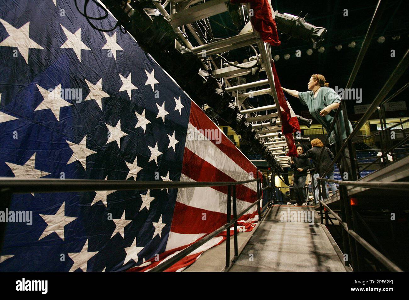 Local 195 stagehand Deborah Terreson leans over a rail to attach ...