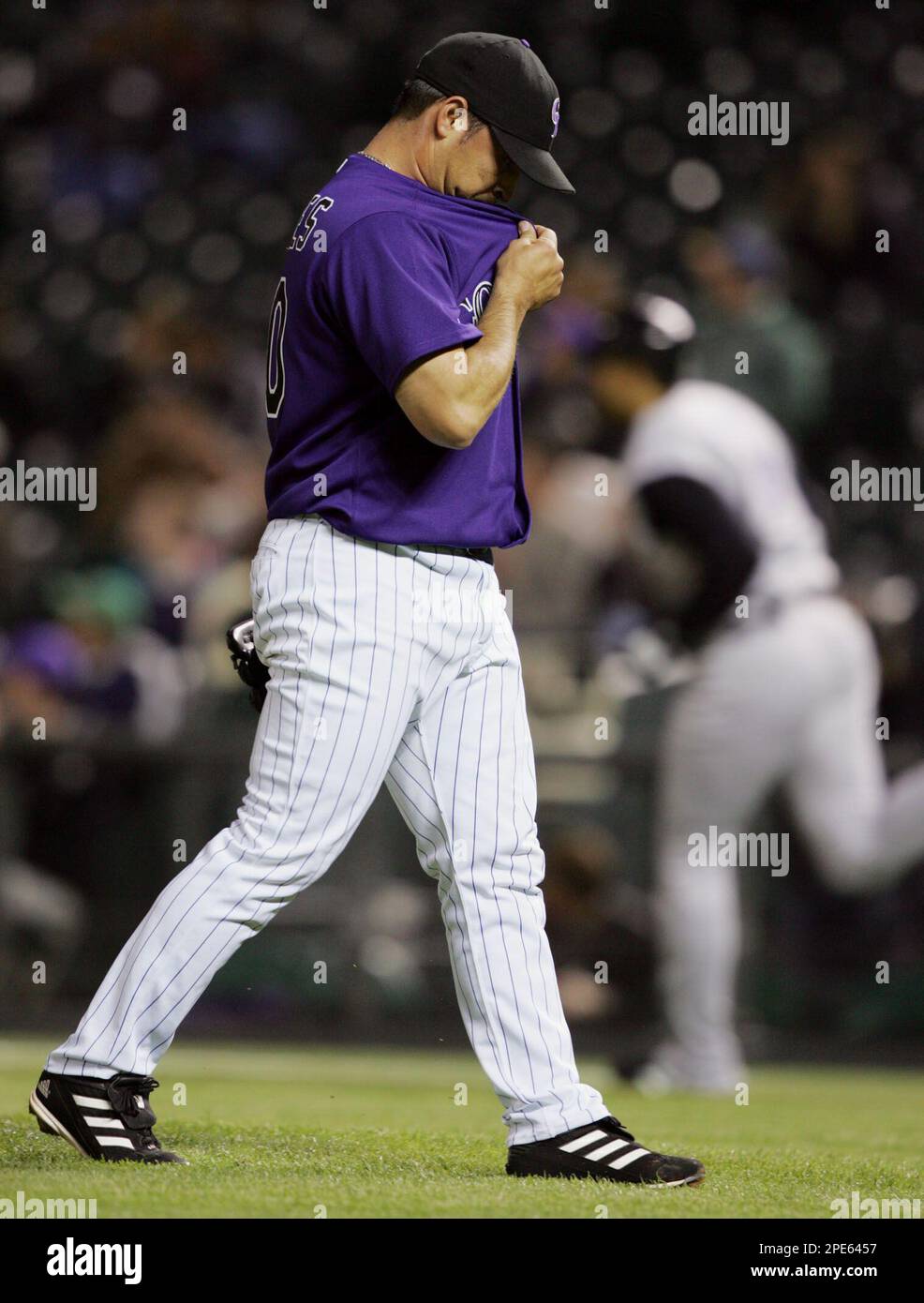 Colorado Rockies relief pitcher David Cortes, front, pulls his jersey ...