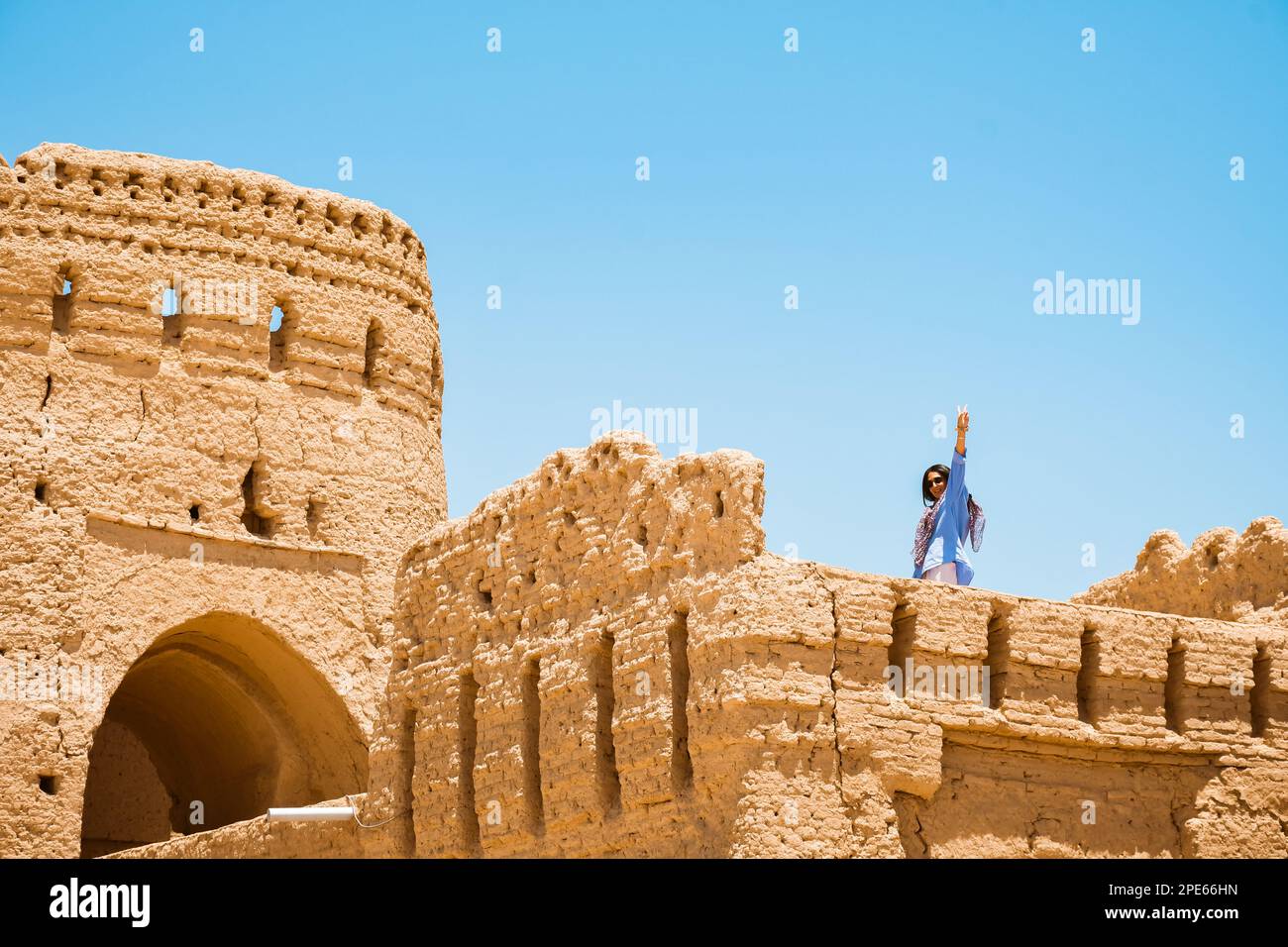 Tourist woman walk visit famous ancient Narin Qal'eh (Qaleh) clay castle in the centre of Meybod ...