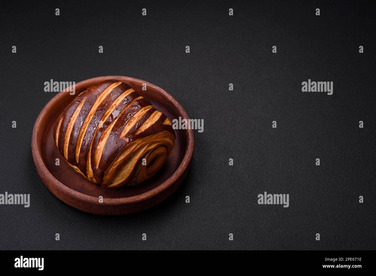 Delicious sweet crispy fresh baked cinnamon bun on dark concrete ...