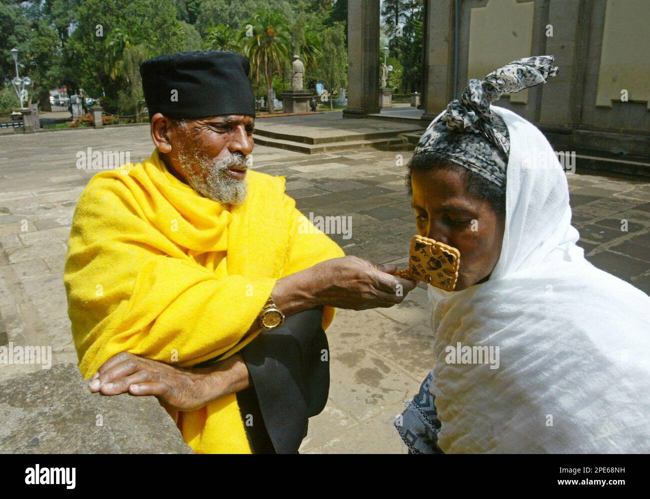 A worshipper kisses the cross of Ethiopian Orthodox priest, Abba Berana ...