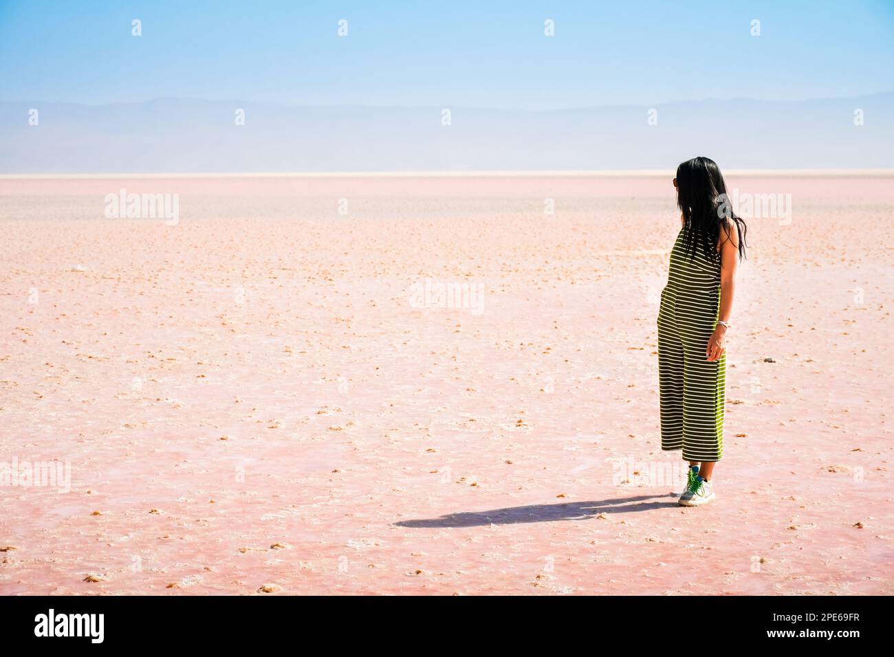 Aerial view young caucasian woman alone walk and explore maharlu salt ...
