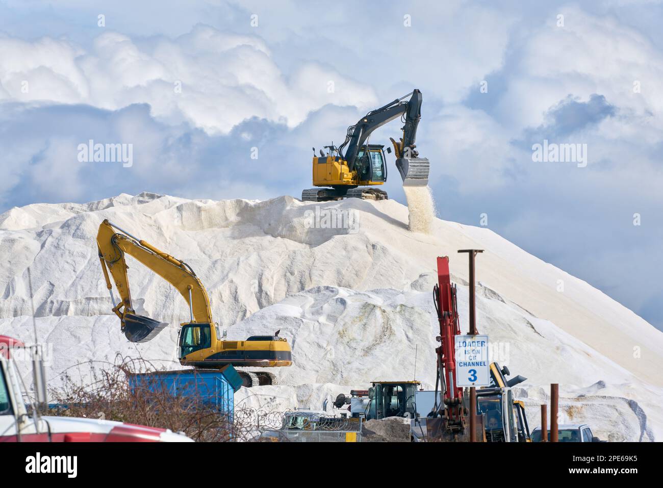 Winter Road Salt Storage Pile. A loader moving salt on a large storage ...