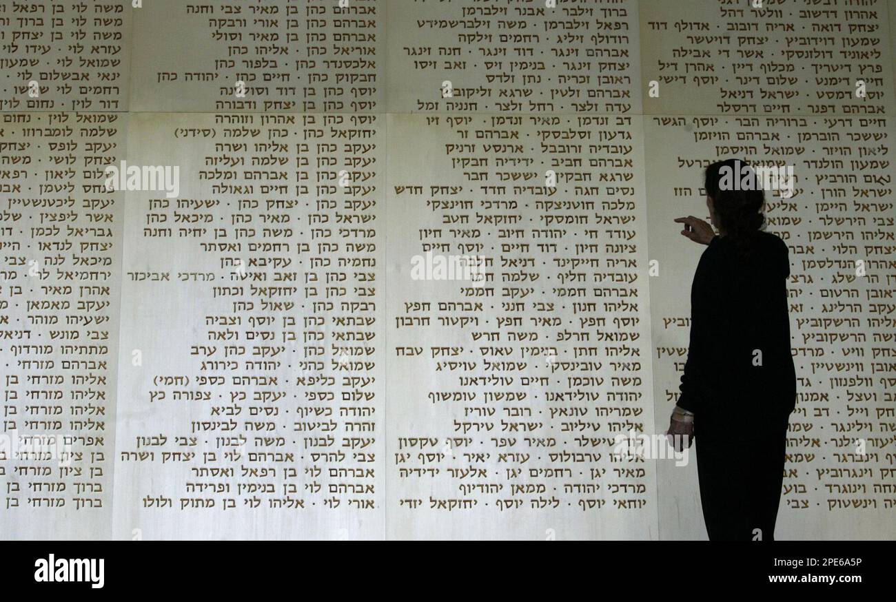 An Israeli reaches out to one of the names of fallen soldiers engraved ...