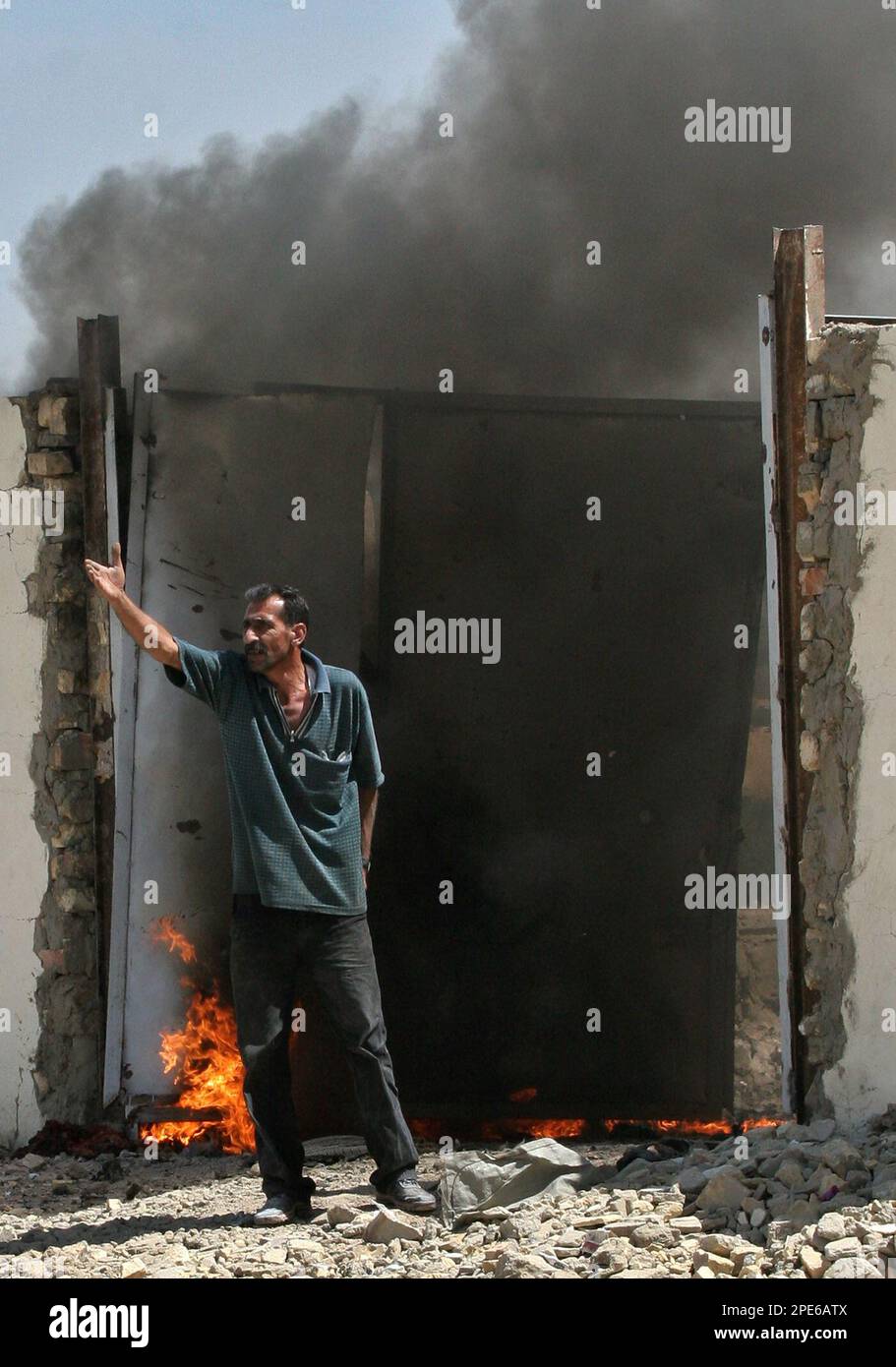 An Iraqi man gestures after a car bomb exploded at the headquarters of ...