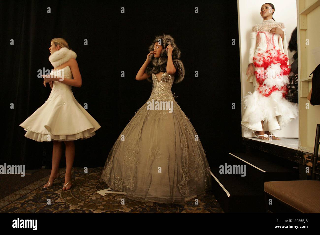 Professional models wait to step onto the runway near the show's end to ...