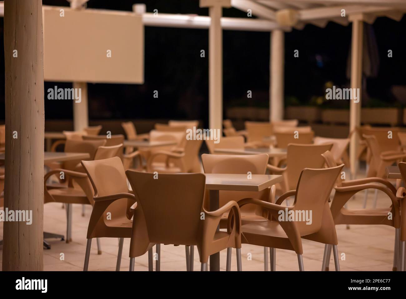 Empty Hotel Beach Cafe With Plastic Chairs And Tables At Night ...
