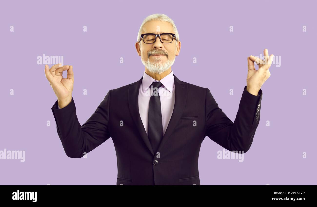 Peaceful old businessman meditate on studio background Stock Photo - Alamy