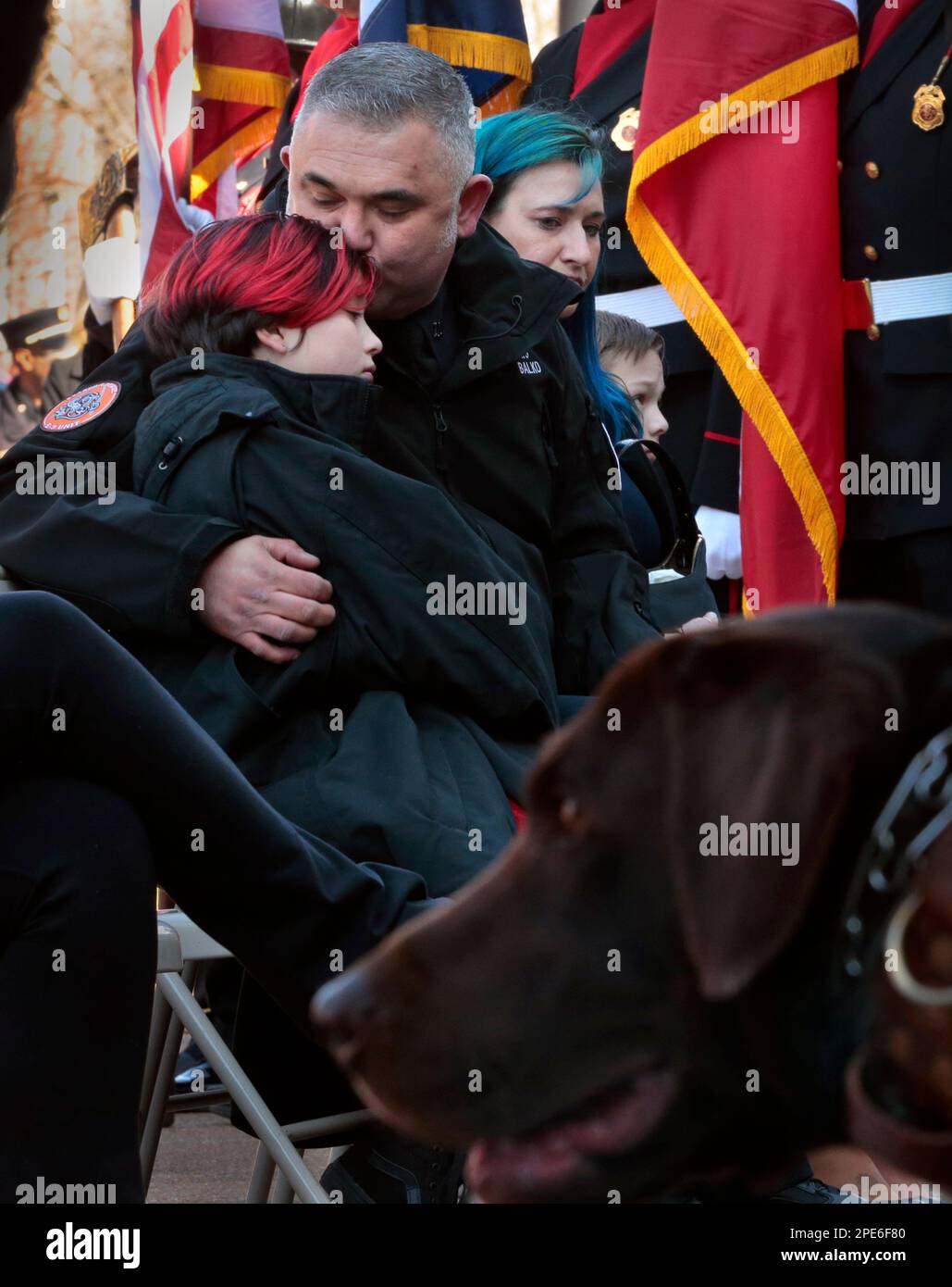 St. Louis firefighter Brent Sevener kisses daughter Mara as he attends ...