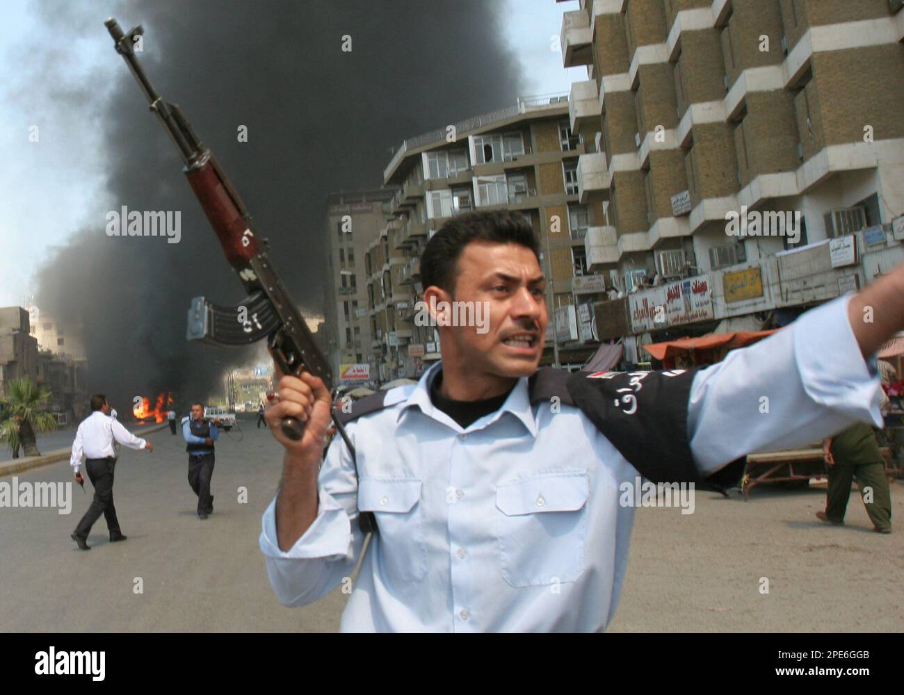 An Iraqi police man arrives to the scene after a car bomb exploded in a ...