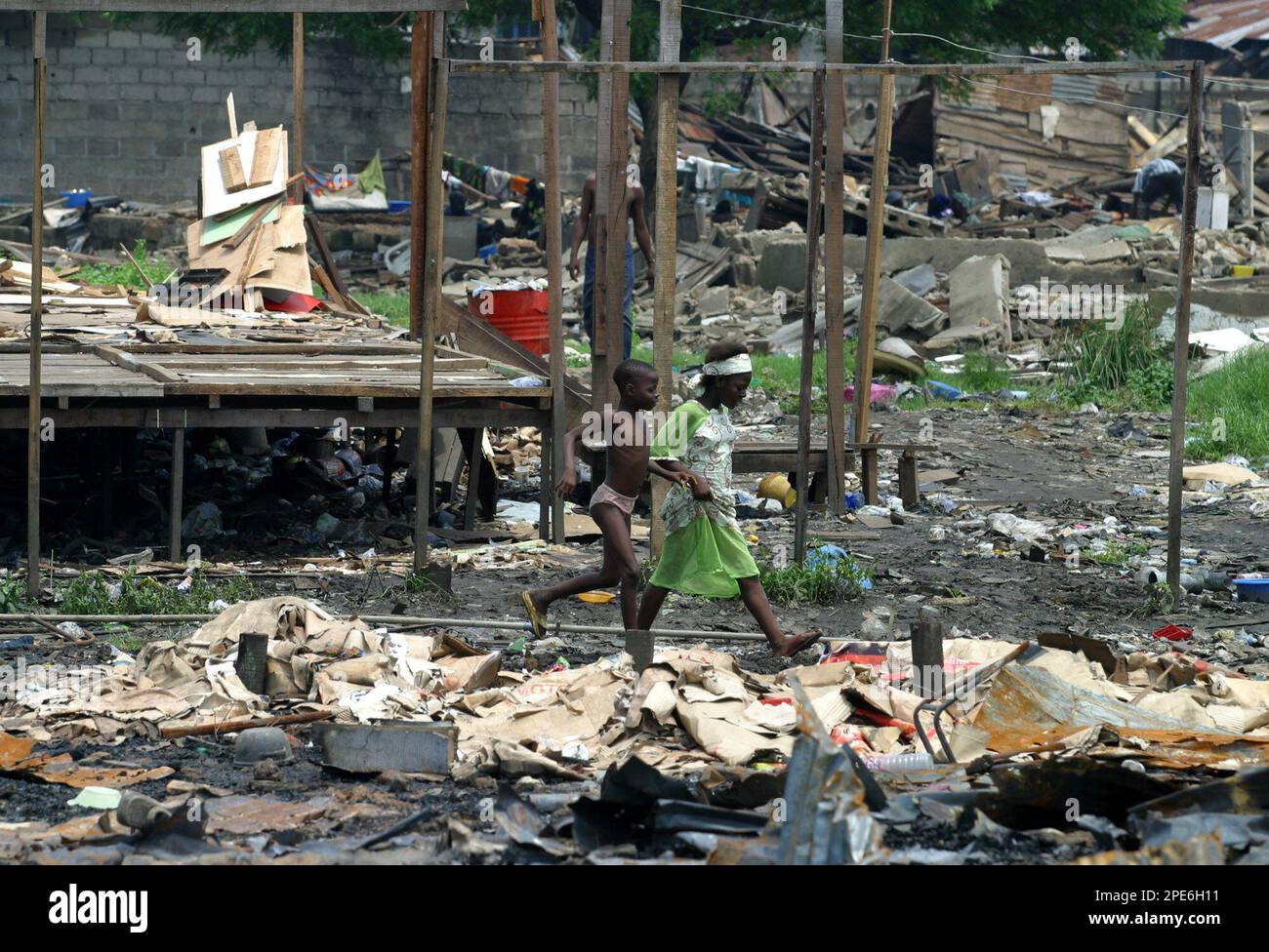 Children walk past demolished houses at the Makoko slum area in Lagos ...