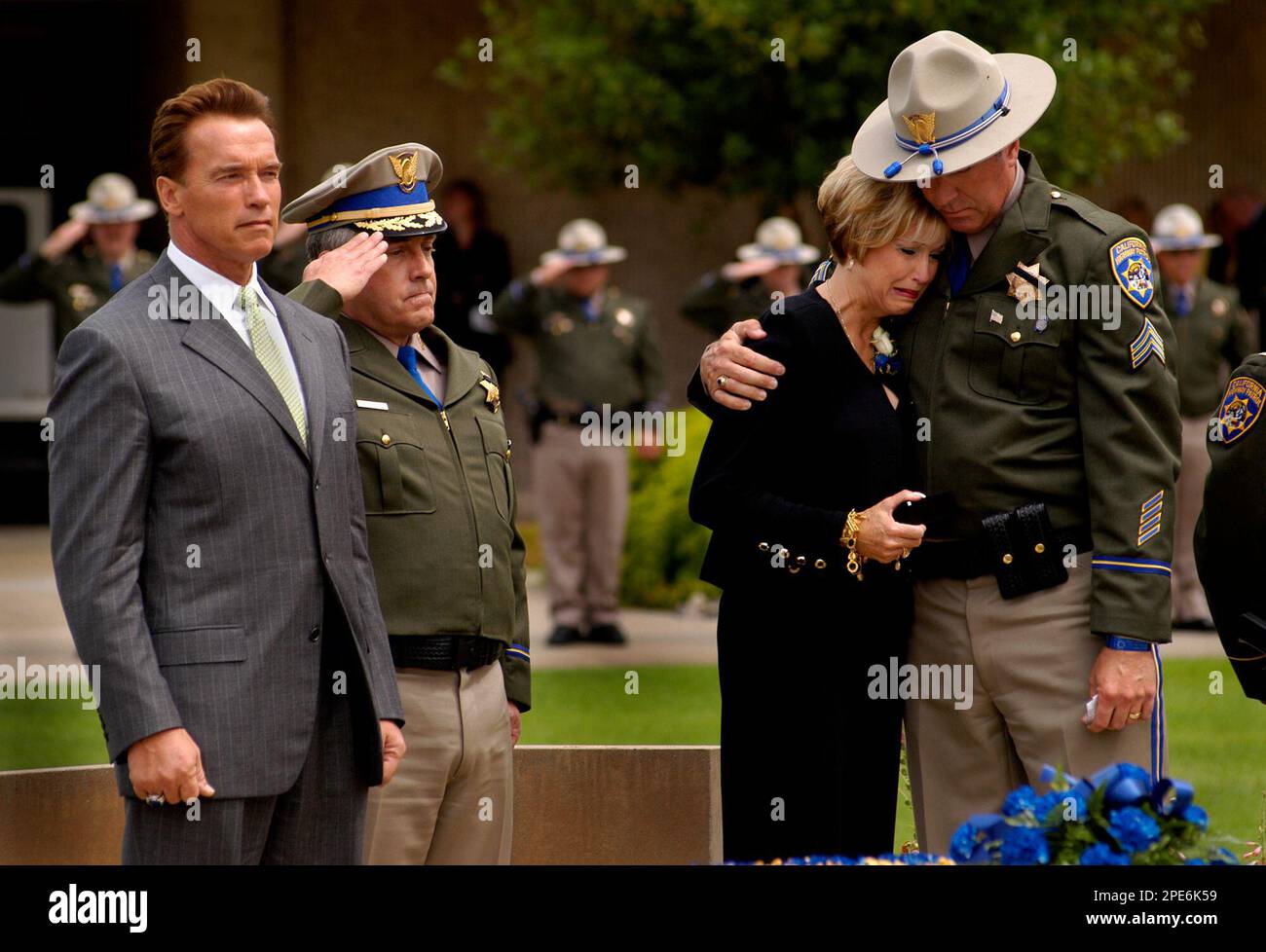Patti Goodman, second from right, is comforted as a wreath is placed at ...