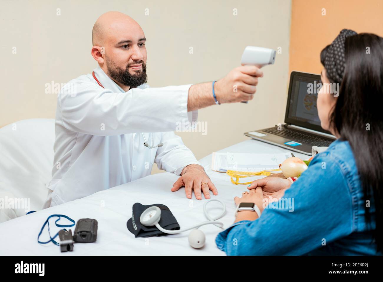 Doctor measuring temperature with infrared gun to female patient ...