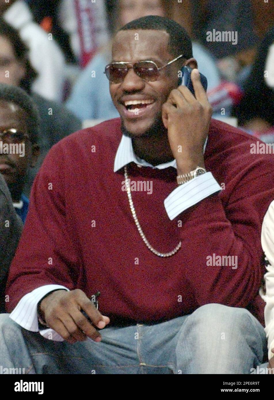 Cleveland Cavaliers' LeBron James talks on the phone while watching ...