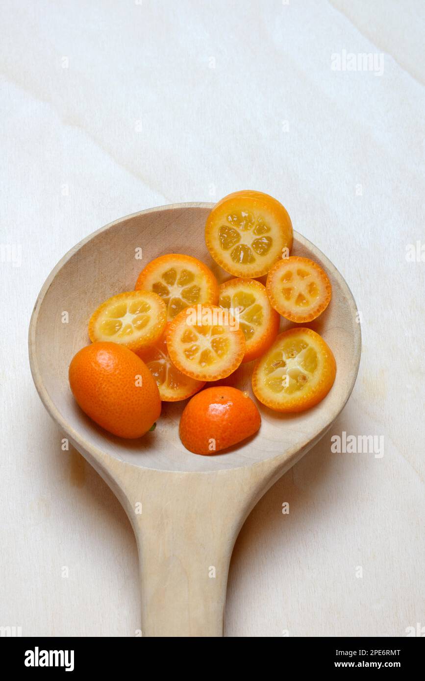 Kumquat (Fortunella) and kumquat slices in wooden ladle Stock Photo - Alamy