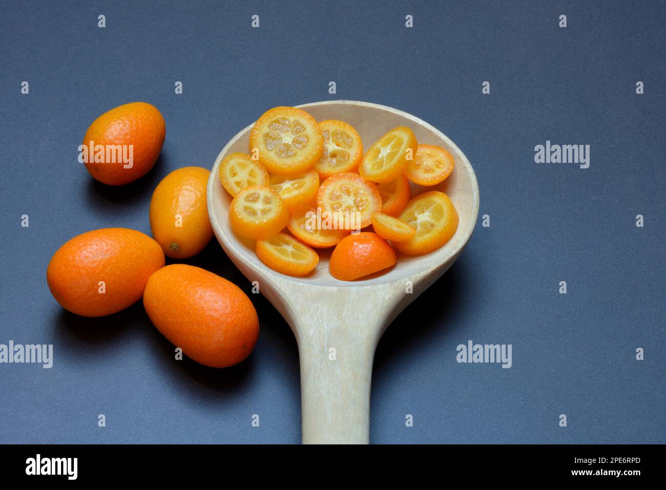 Kumquat (Fortunella) and kumquat slices in wooden ladle Stock Photo - Alamy