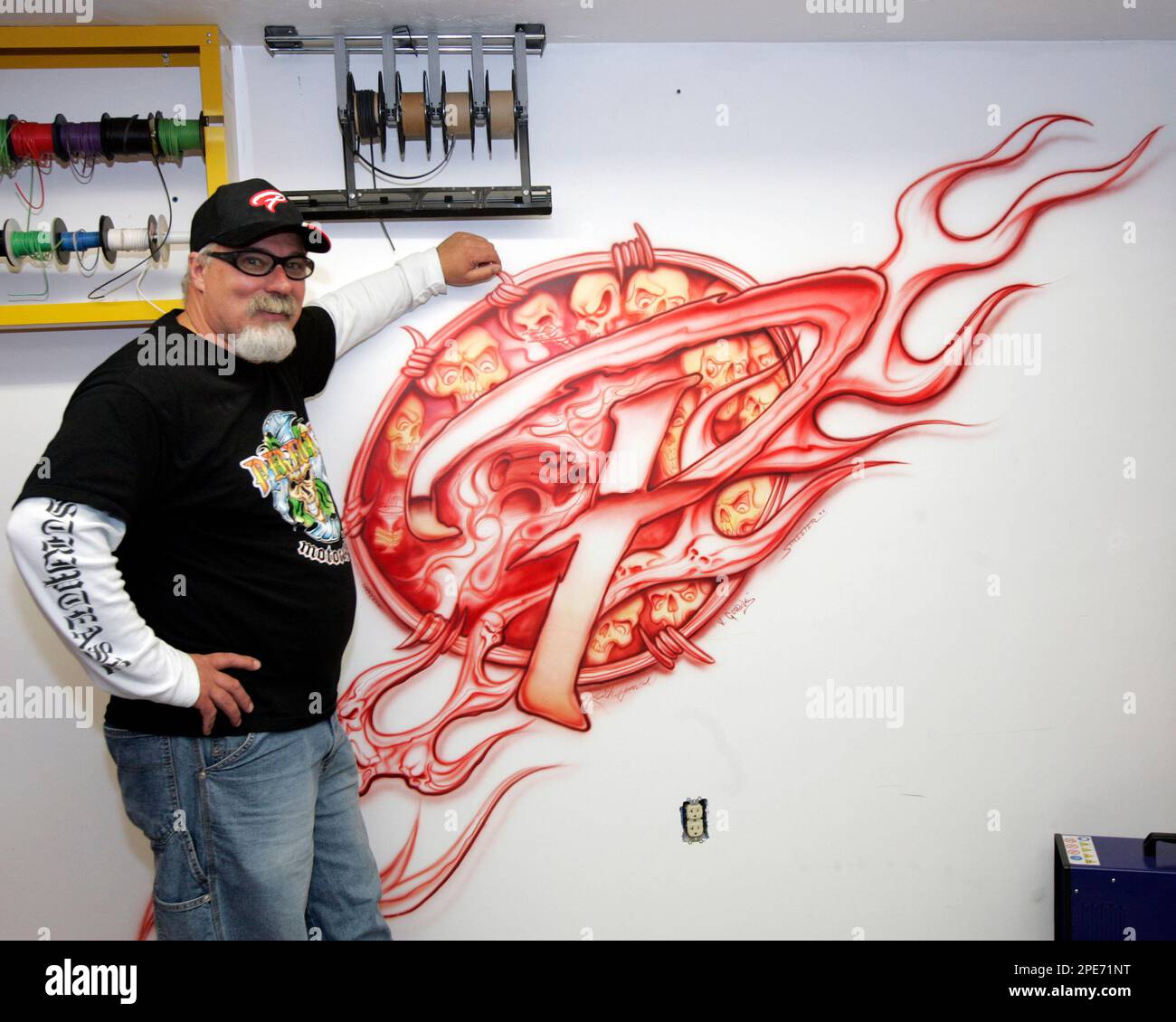 Dave Perewitz poses in front of the mural painted in the assembly room ...