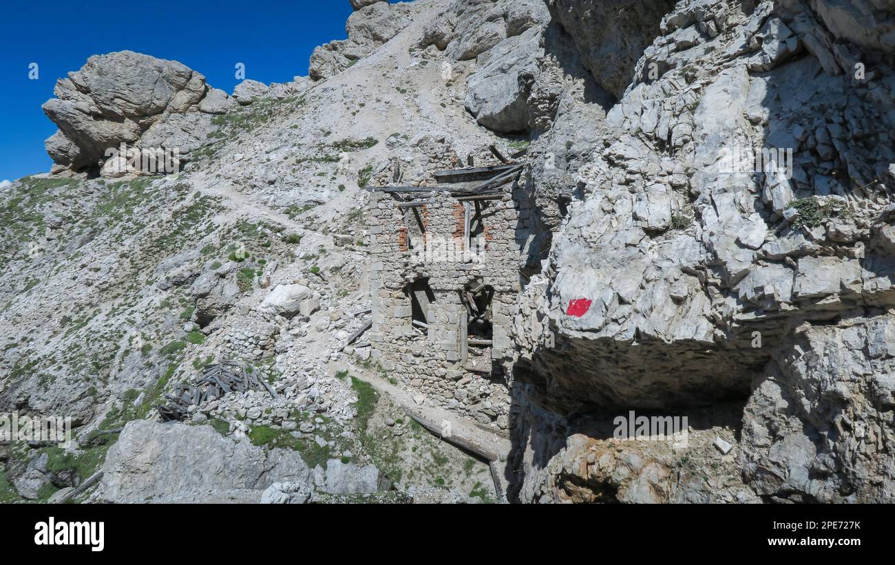 An old, destroyed building standing near the trail in the Dolomites ...