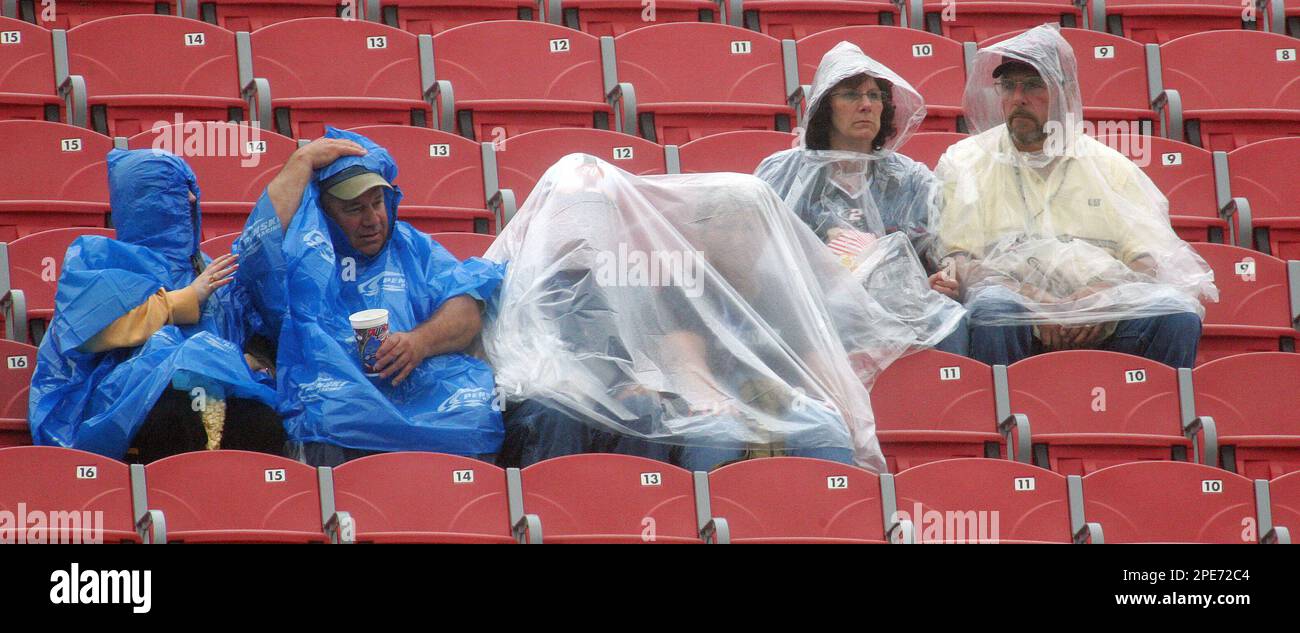 Race fans sit in the rain as they wait for the weather delayed start of ...