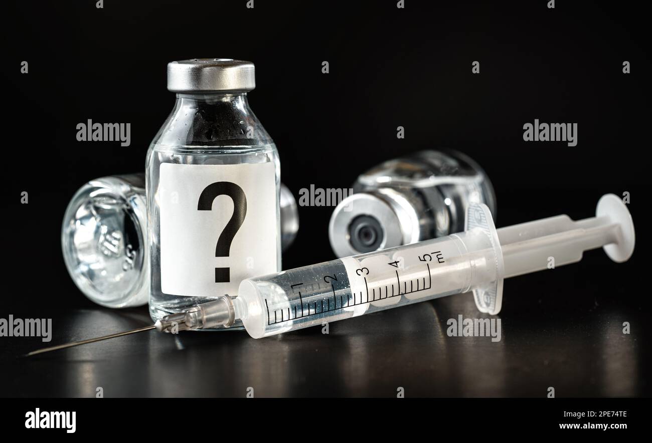 Vaccine bottle with hypodermic syringe needle near, question mark on ...