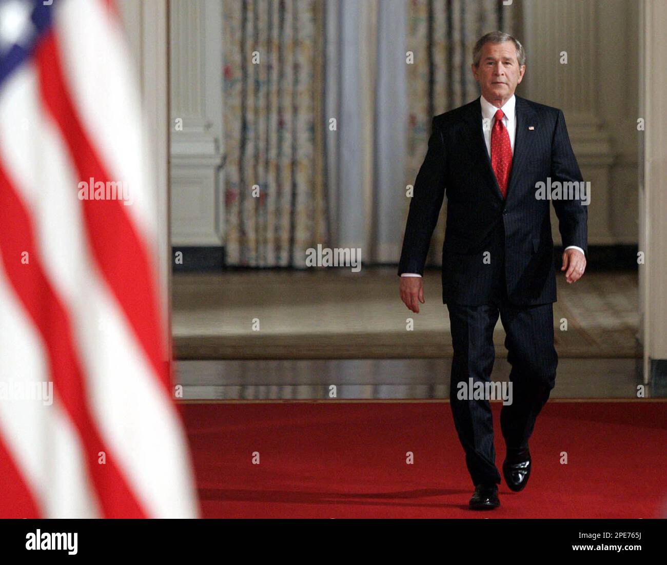 President Bush walks in the Cross Hall to a news conference Thursday ...