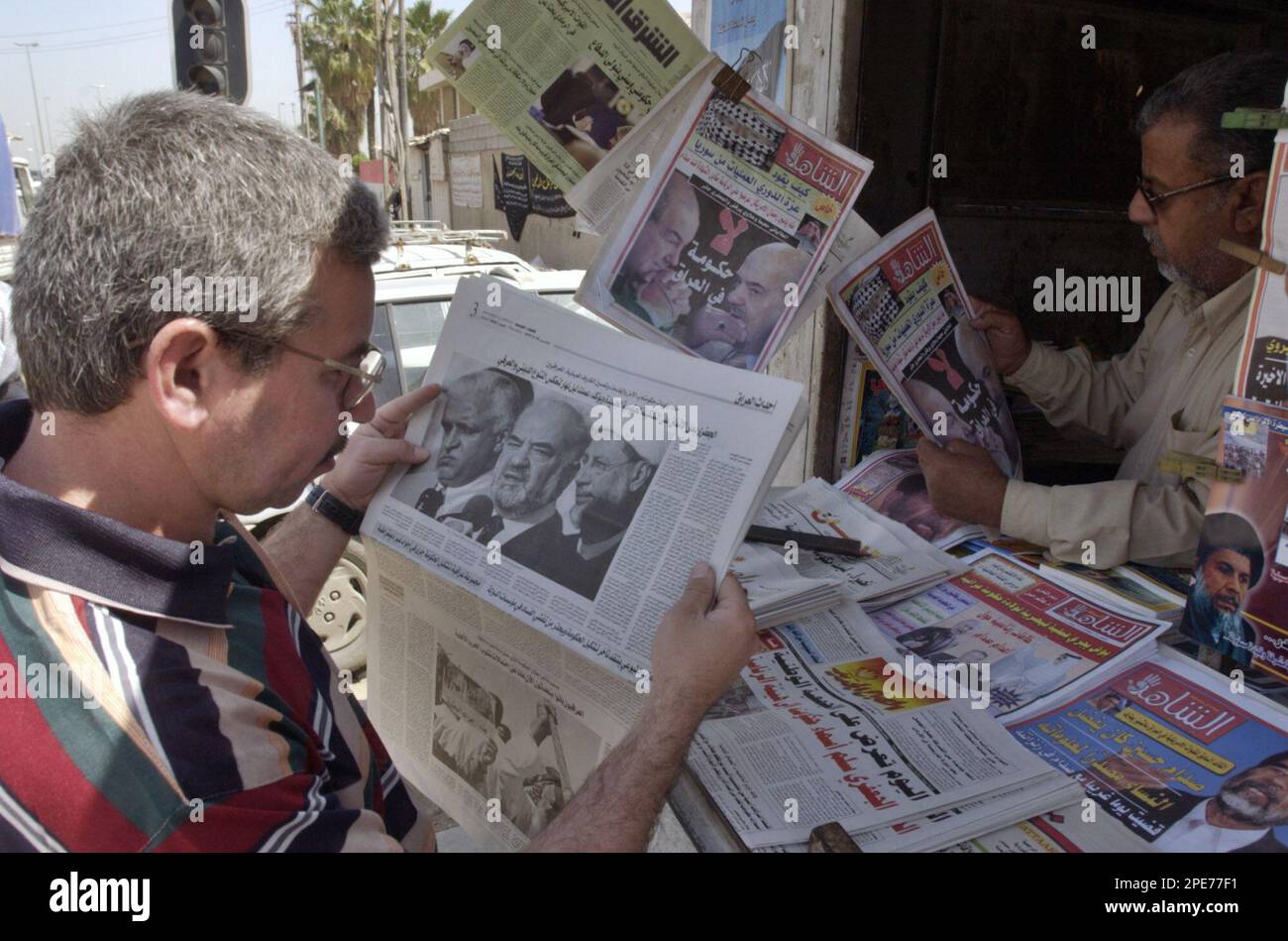 Iraqi men read local newspapers with front page stories of Iraqi Prime ...