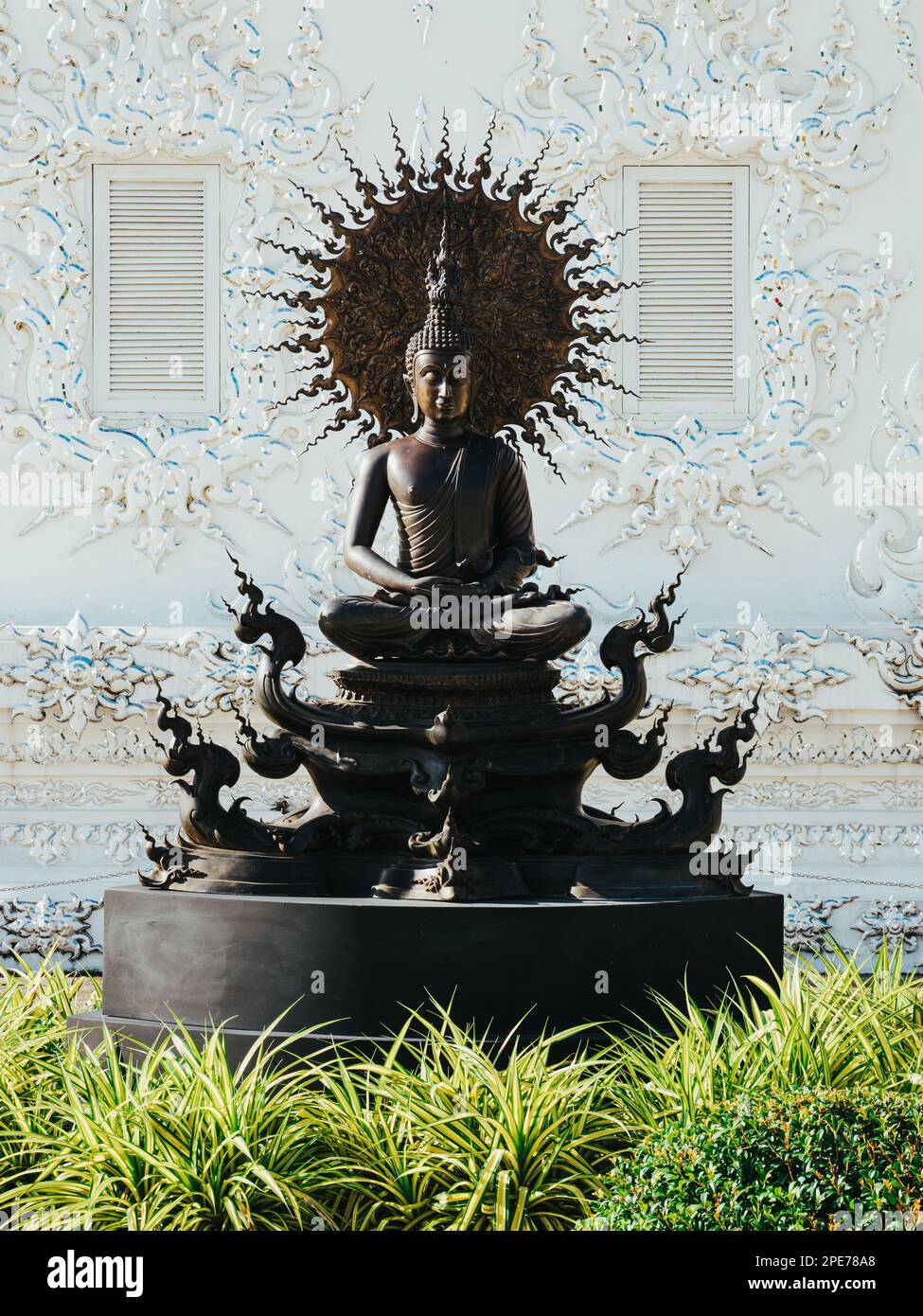 A sculpture of a figure sitting atop a small table in an indoor space ...