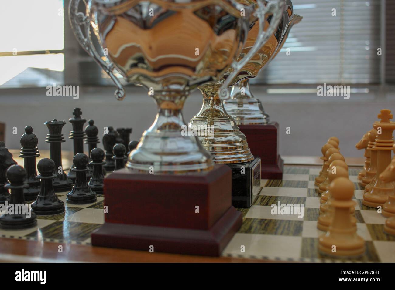 three trophies on the chessboard for the winners Stock Photo - Alamy