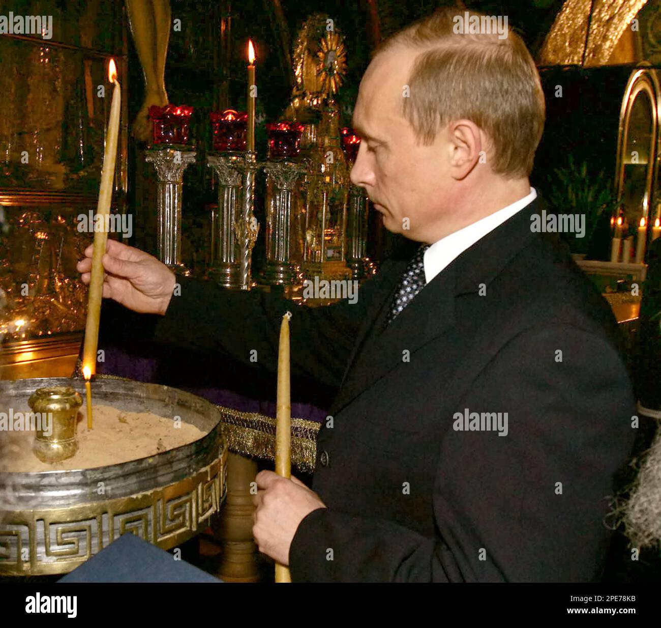Russian President Vladimir Putin lights a candle, as he visits the ...
