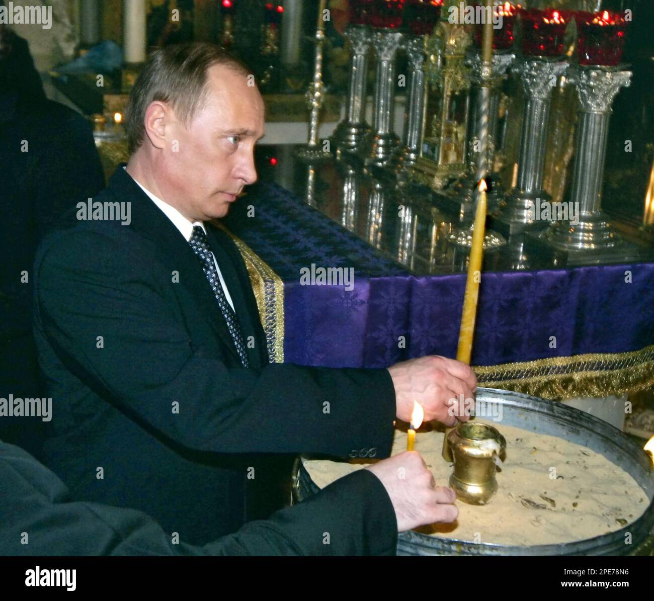 Russian President Vladimir Putin lights a candle, as he visits the ...