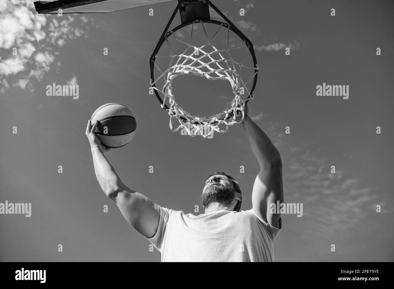 muscular man player throw basketball ball through basket, male ...