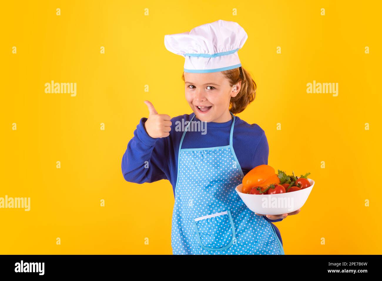 Kid cook hold plate with vegetables. Chef kid preparing healthy food ...