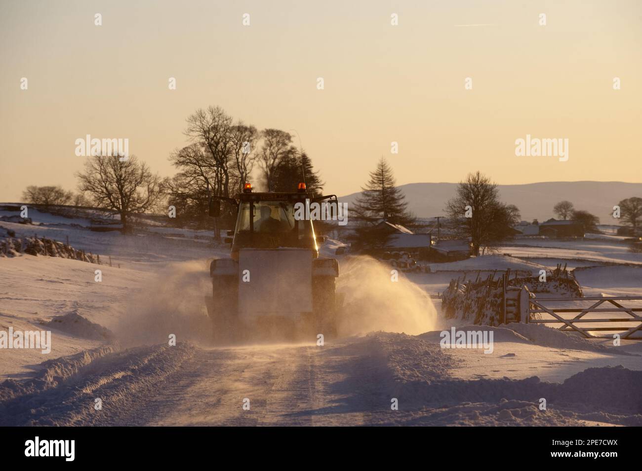Snow plough clearing snow-covered country road, Cumbria, England ...