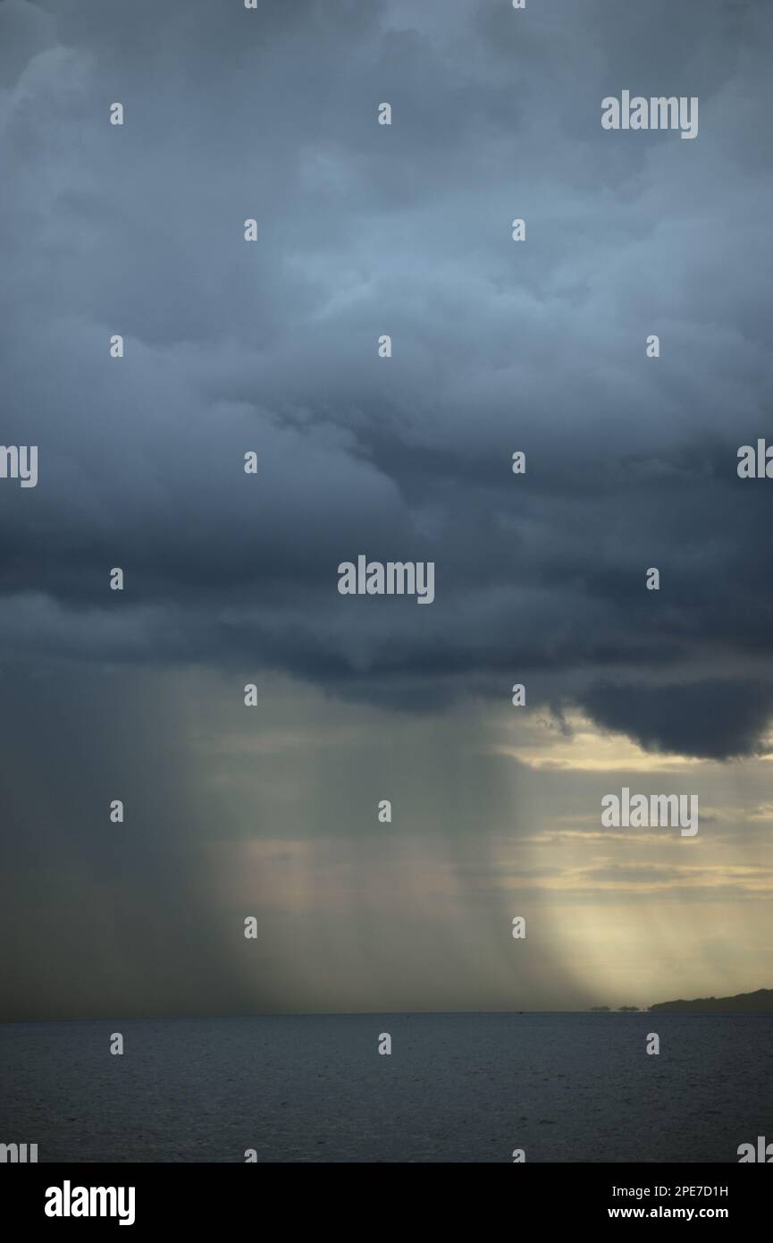 Rainstorm approaching over sea at dusk, Raja Ampat Islands (Four Kings ...