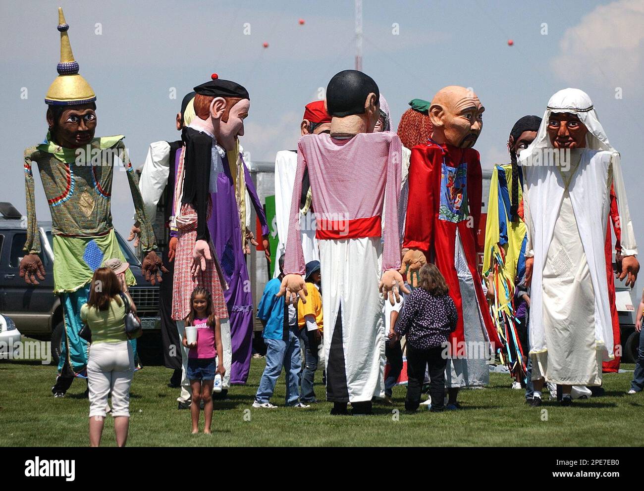 Visitors look at 15-foot-tall puppets created by artist Paz along with ...