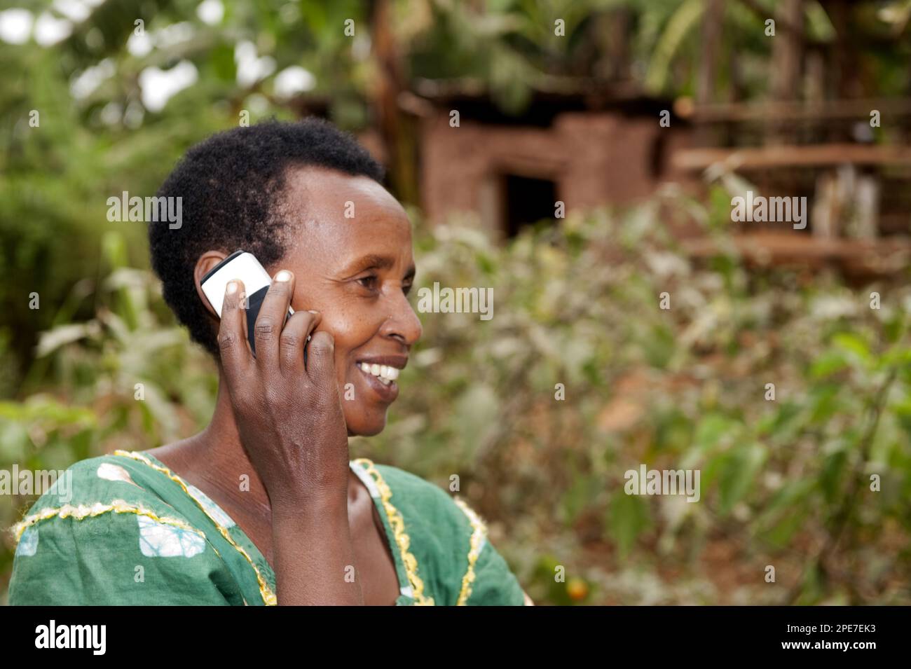 Lady on mobile phone gardening, Rwanda Stock Photo - Alamy