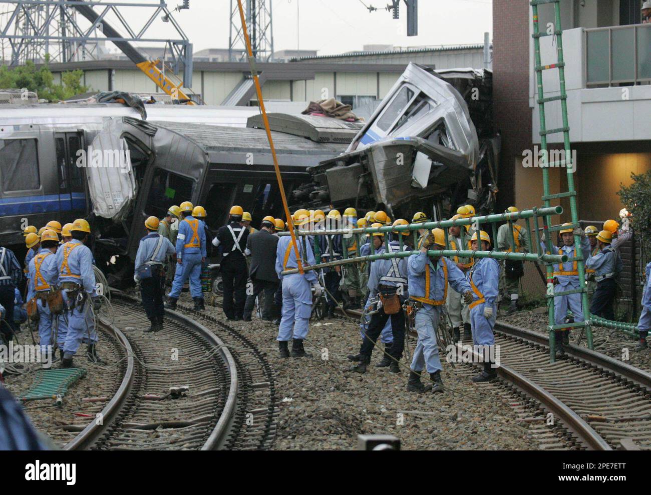 Rescuers gather around the wreckage of a derailed commuter train after a rescue operation in ...