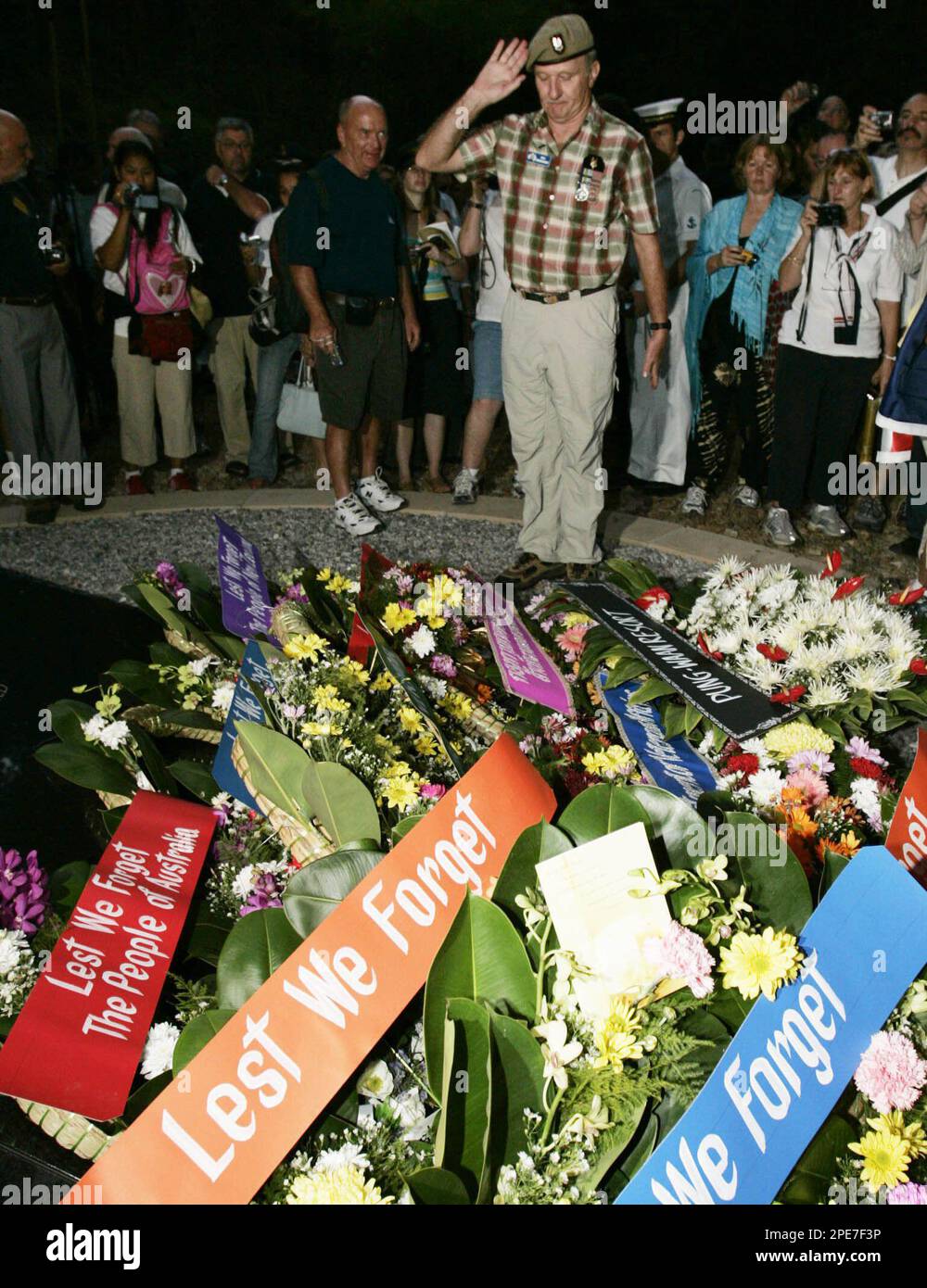 A family member of Australian World War II veteran salutes as he lays a ...