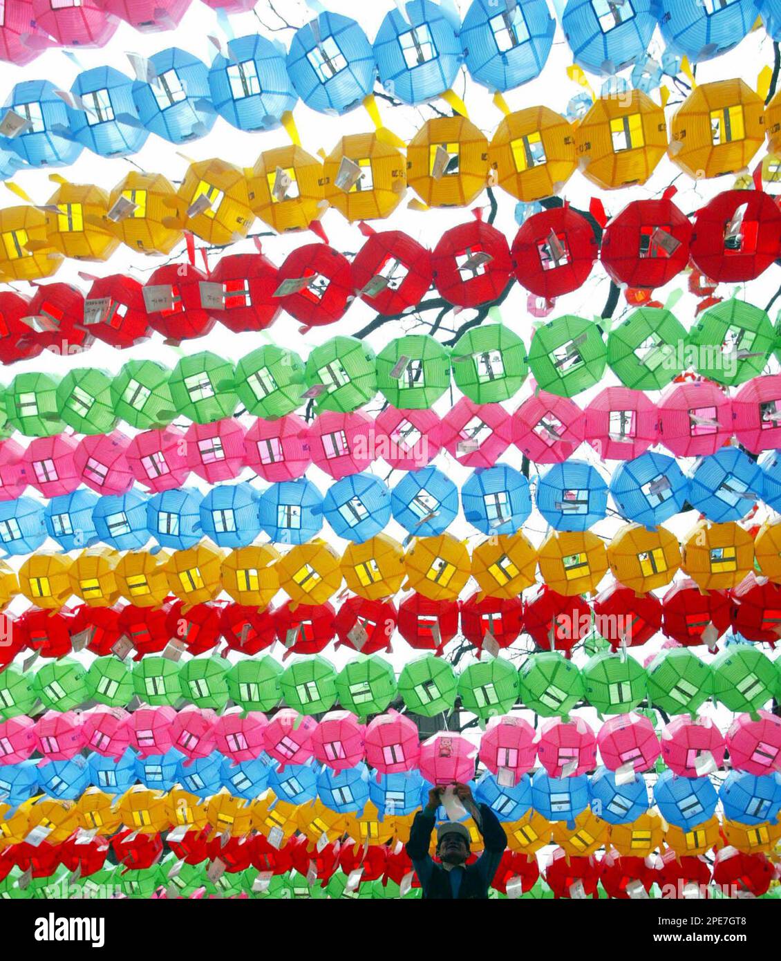 Under a sea of hanging paper lanterns, a worker at Chogye Buddhist ...