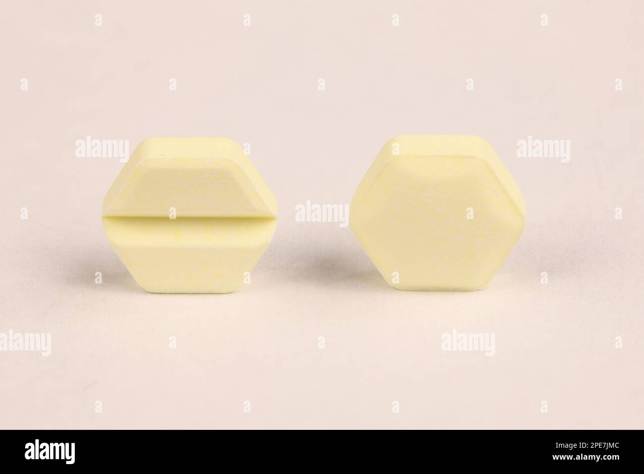 Hexagonal pills on light pink background. Extreme closeup. High ...