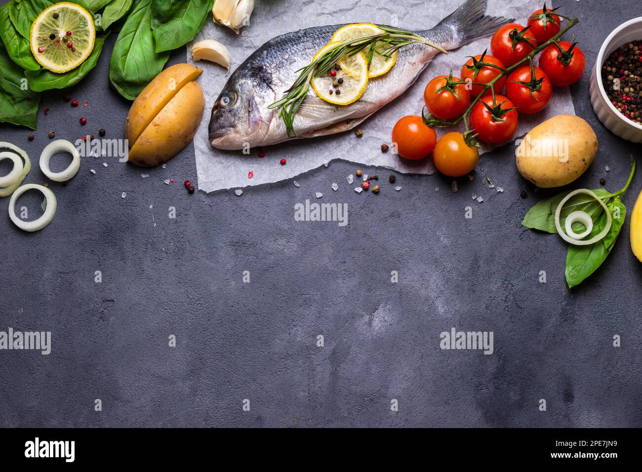 Raw fish with fresh ingredients ready to cook. Fish, lemon, herbs ...
