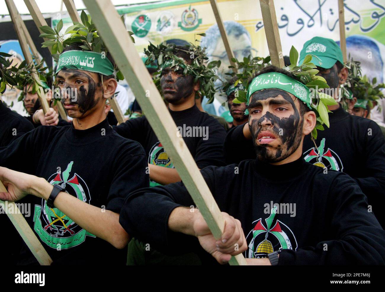 Palestinian Hamas members march with their faces painted during a rally ...