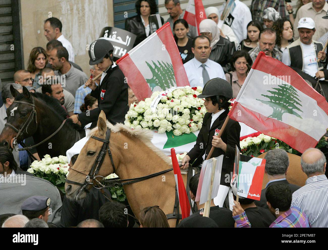 Horse riders carry Lebanese flags while escorted the coffin of Bassel ...