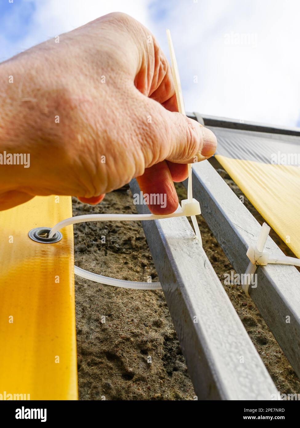 Fastening process of the outdoor vinyl advertising banner to the metal ...