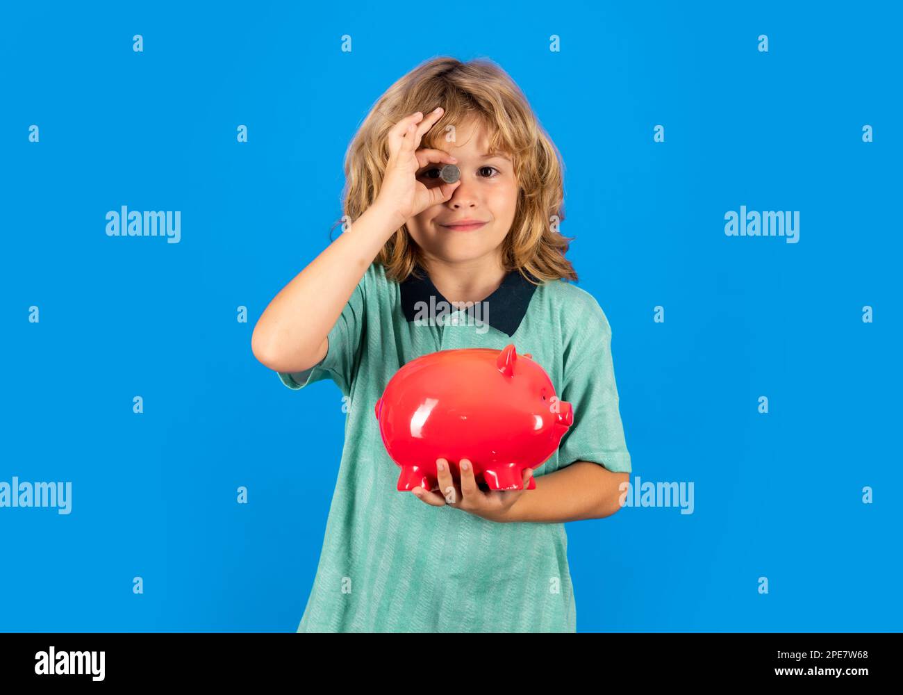 Saving money concept. Kid putting coin into piggy bank for saving with ...