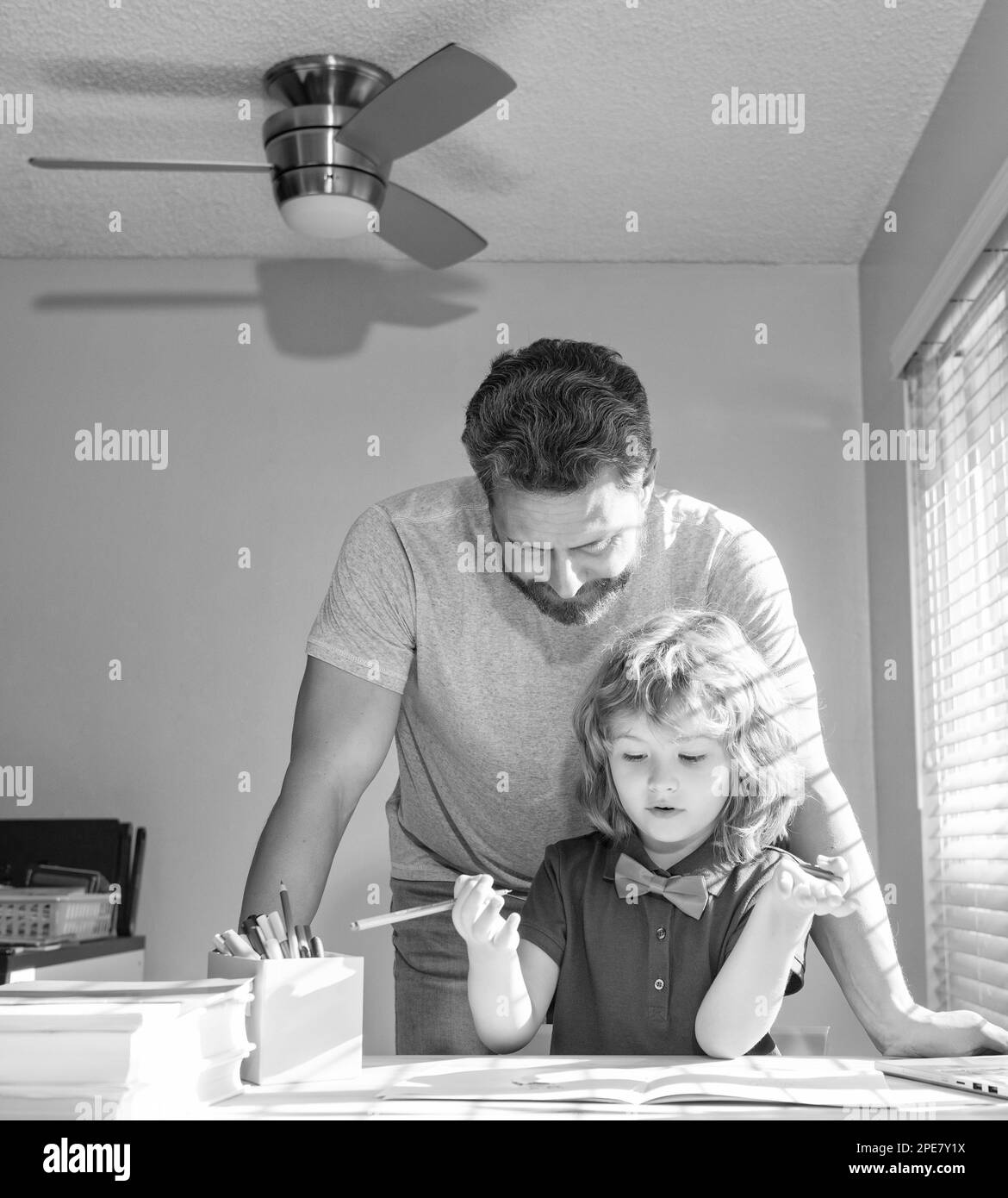 back to school. helping father and son writing at home. family and ...