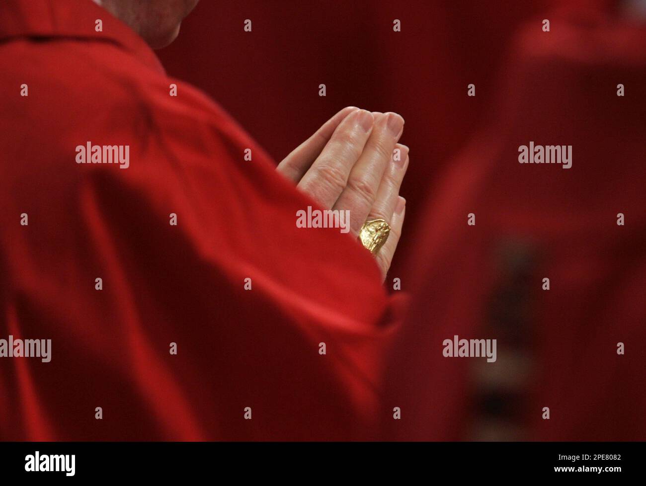 A cardinal joins his hands in prayer during a Mass in St. Peter's ...