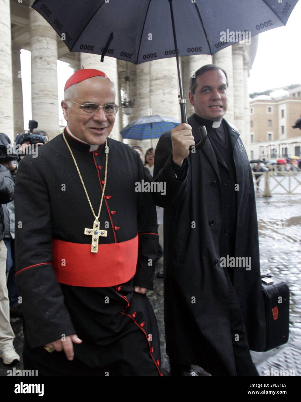 Portuguese Cardinal Jose' Saraiva Martins walks with an aide carrying ...