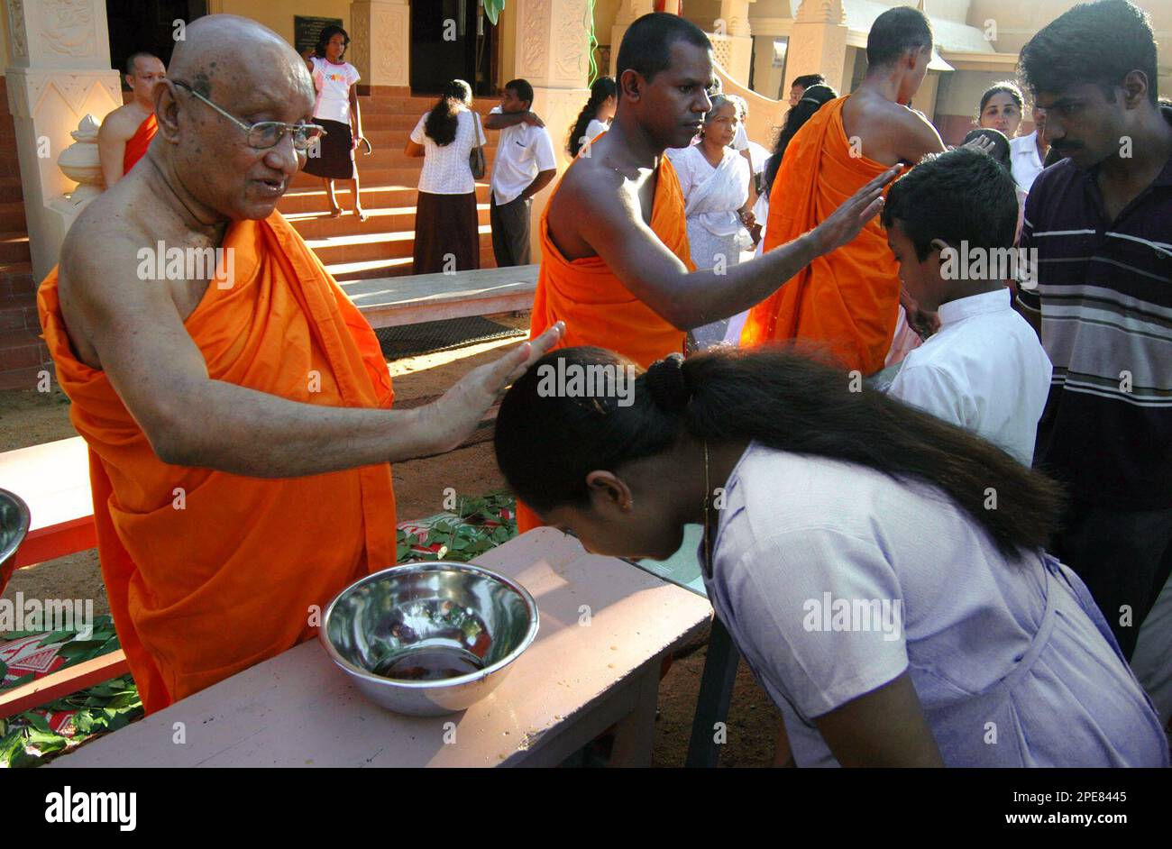 Buddhist monks anoint devotees as part of a traditional New Years ...