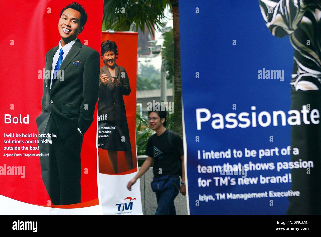A Malaysian walks past Malaysia's largest telecommunications company ...